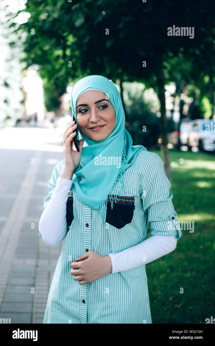 Beautiful muslim woman talking by smartphone at street Stock Photo - Alamy