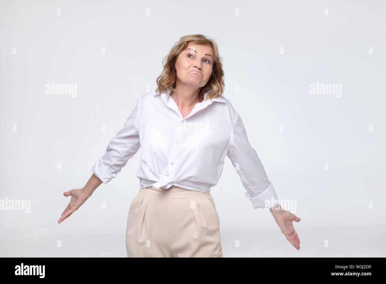 Pretty mature woman retired boss looking confused shrugs her shoulders ...