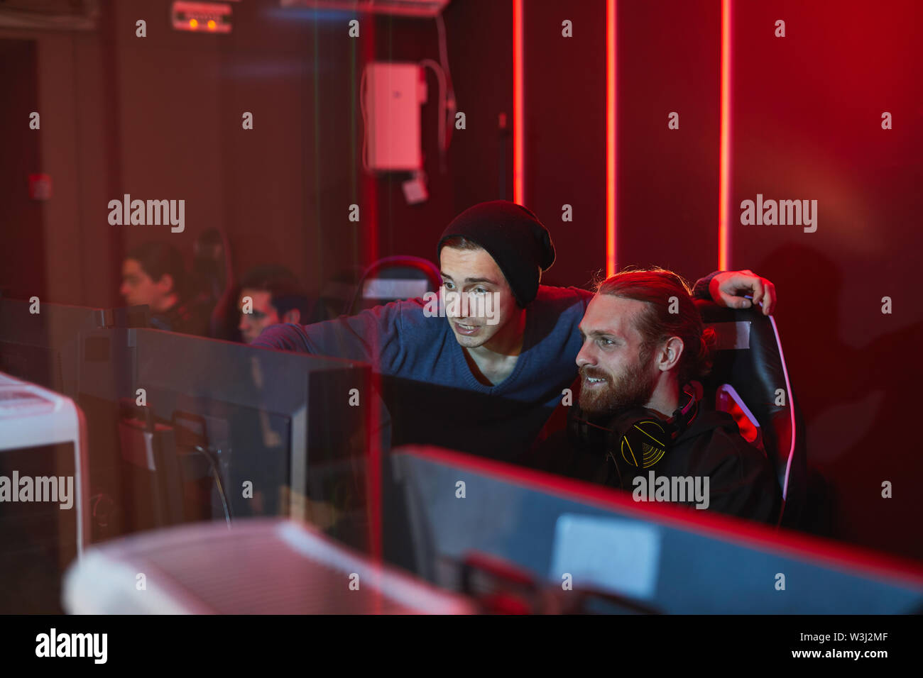 Emotional young hipster friends looking attentively at monitor and ...