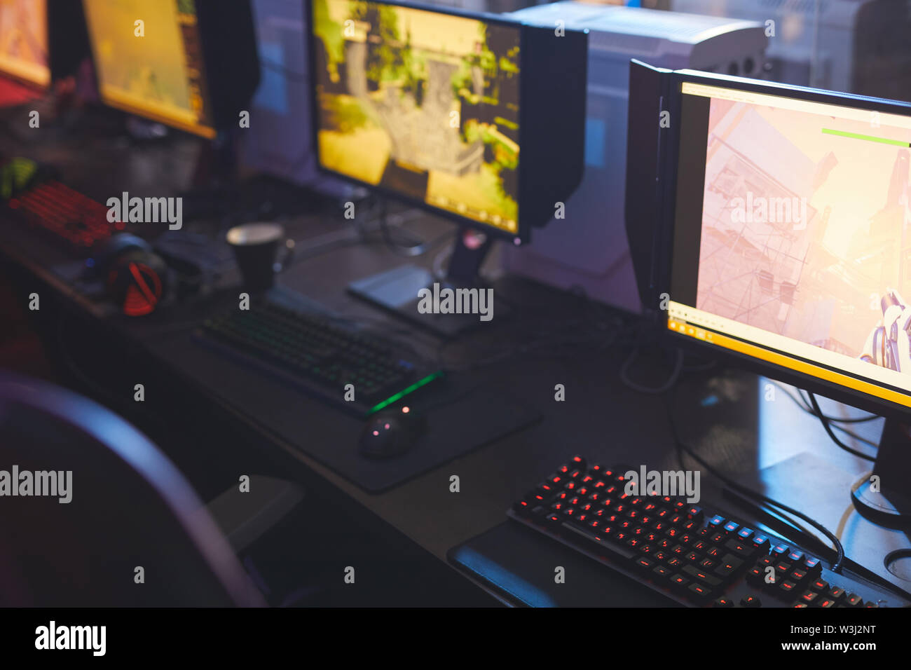 Close-up of computer monitors with arcade game pictures place on table ...