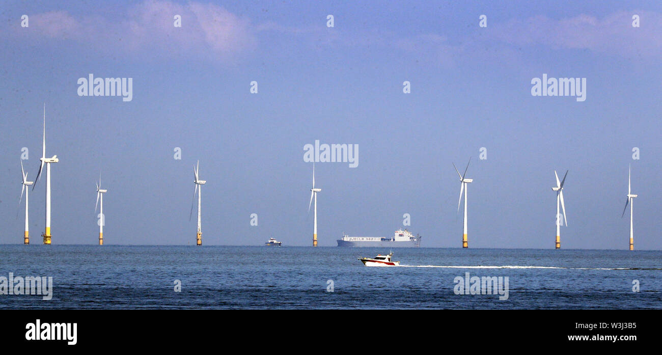 Boats pass the Kentish Flats Offshore Wind Farm during the morning ...