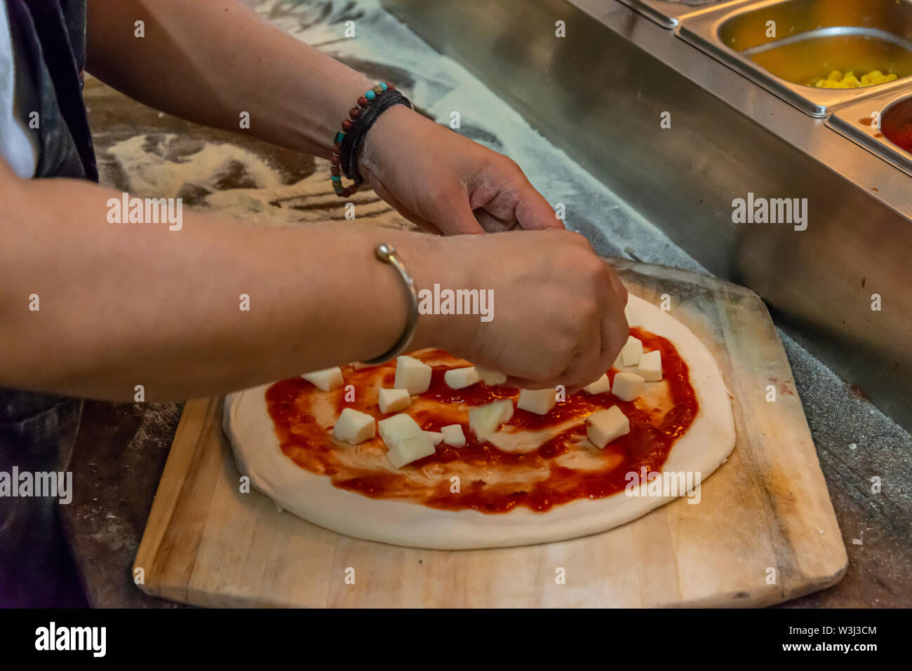 Adding cheese to a margherita pizza Stock Photo - Alamy