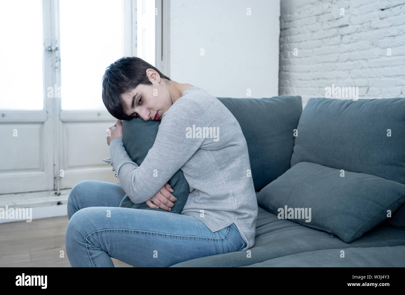 Beautiful desperate and depressed young woman on sofa feeling sad ...
