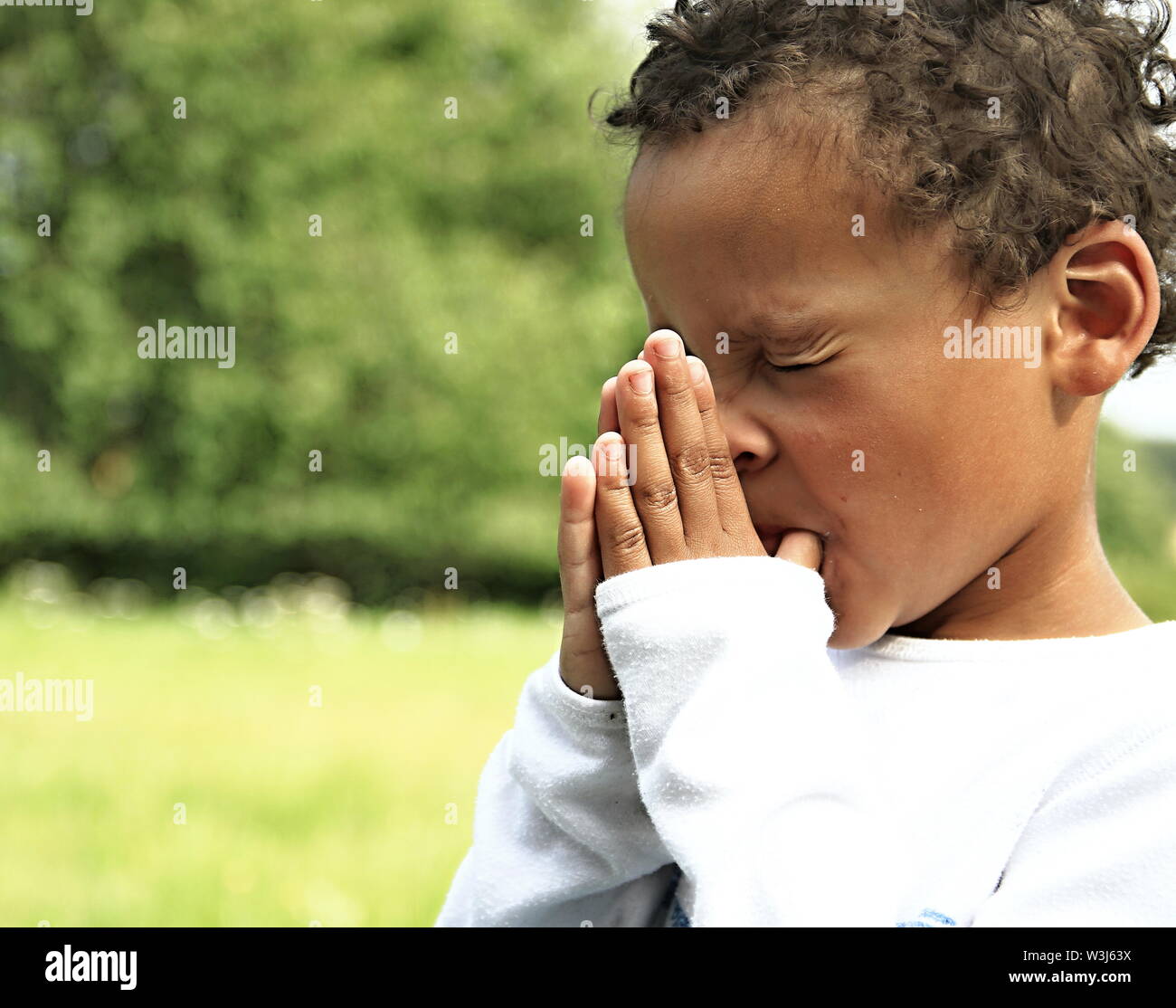 little boy praying to God and being religious stock image with hands ...