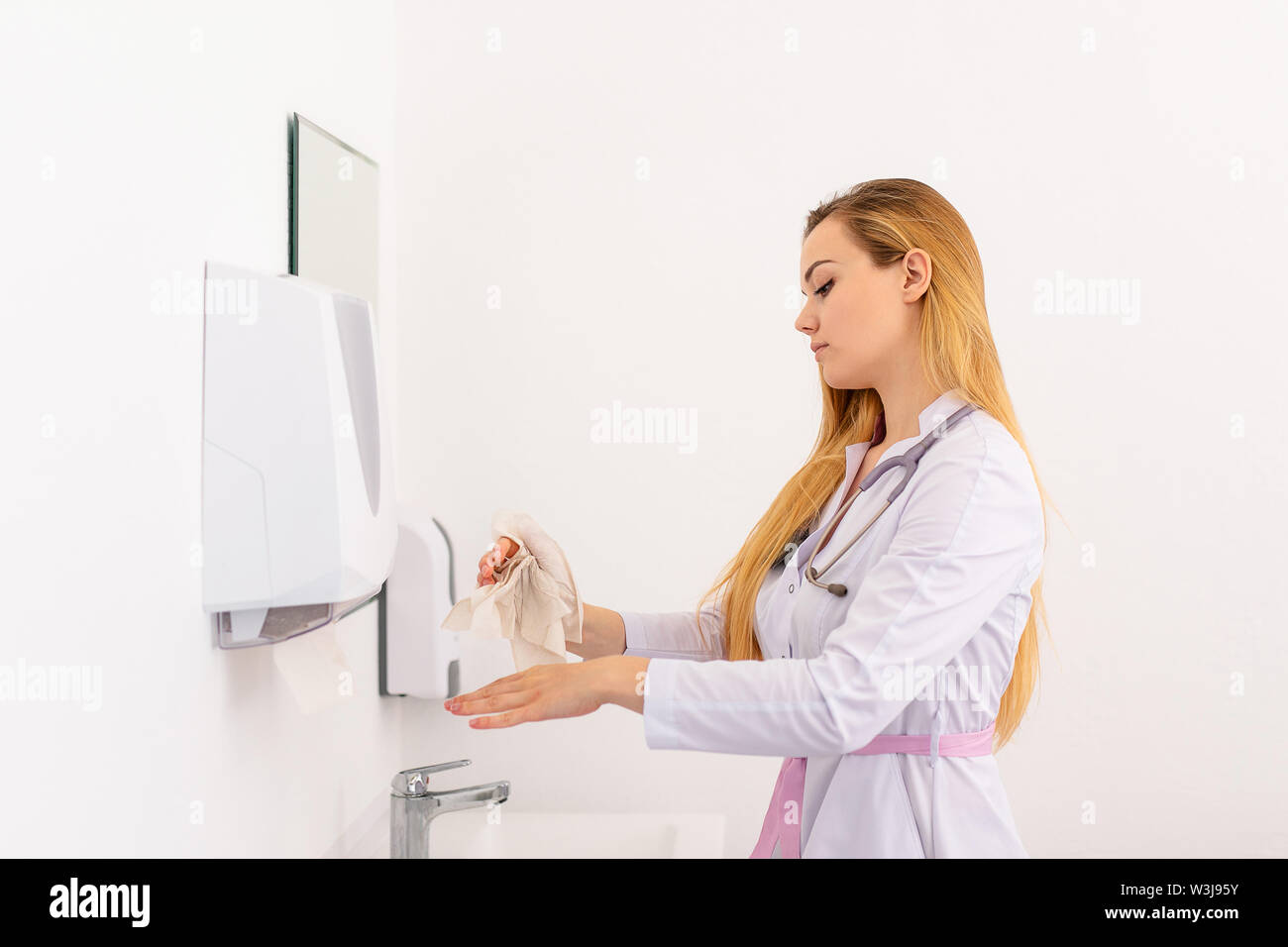 Young female doctor washing her hands befor patient admission in new ...