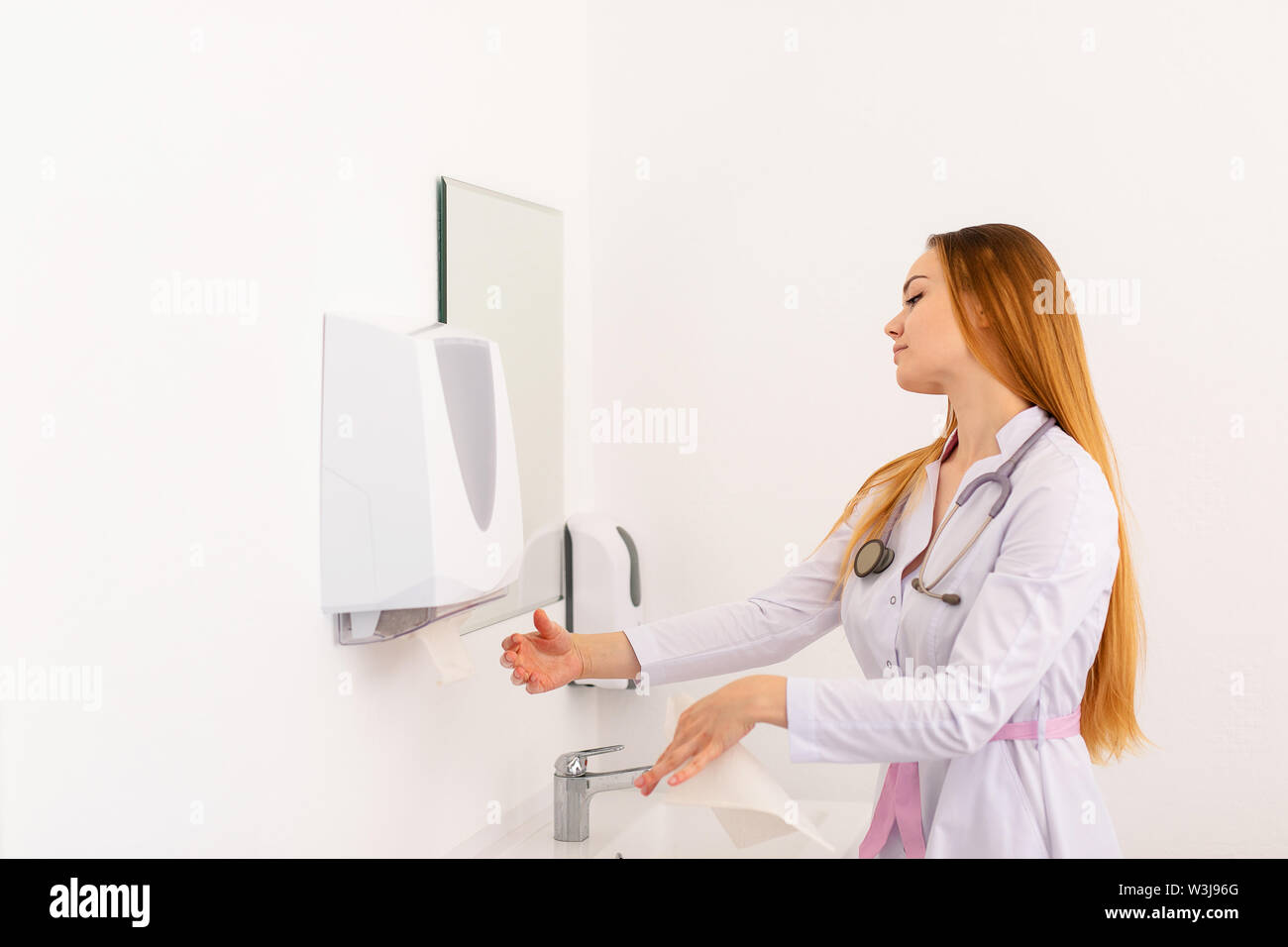 Young female doctor washing her hands befor patient admission in new ...