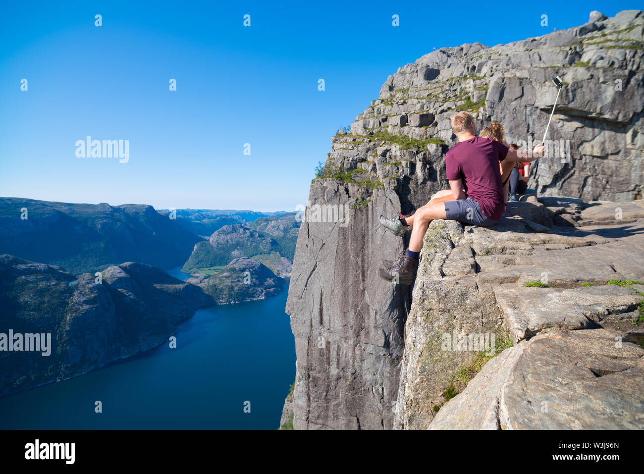 PULPIT ROCK, NORWAY - JULY 26, 2018: Unknown tourists sitting on the ...