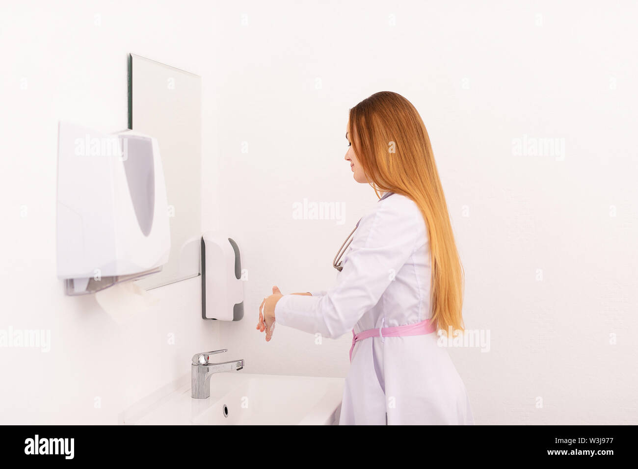 Young female doctor washing her hands befor patient admission in new ...