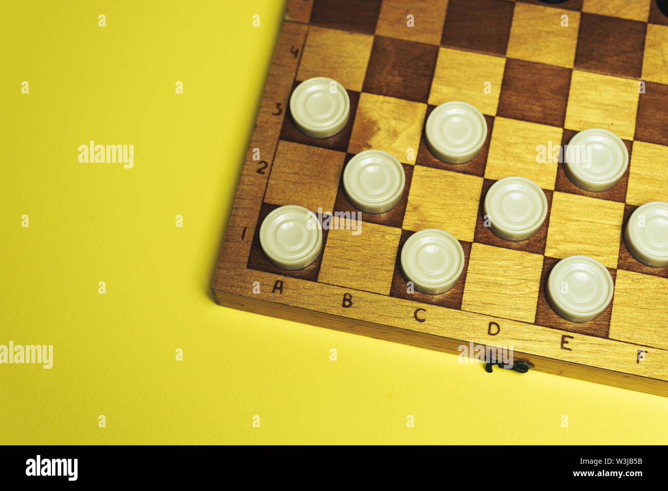 Chess baord with chess on a yellow table background Stock Photo - Alamy