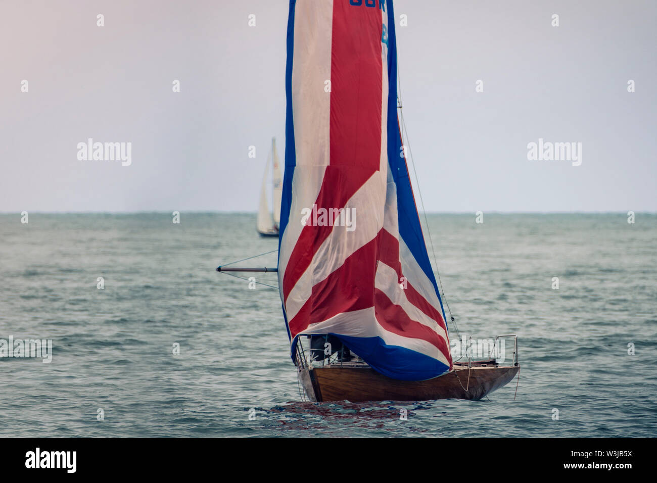 Sailing boat wrapped with spinnaker tacking at no wind condition Stock Photo - Alamy