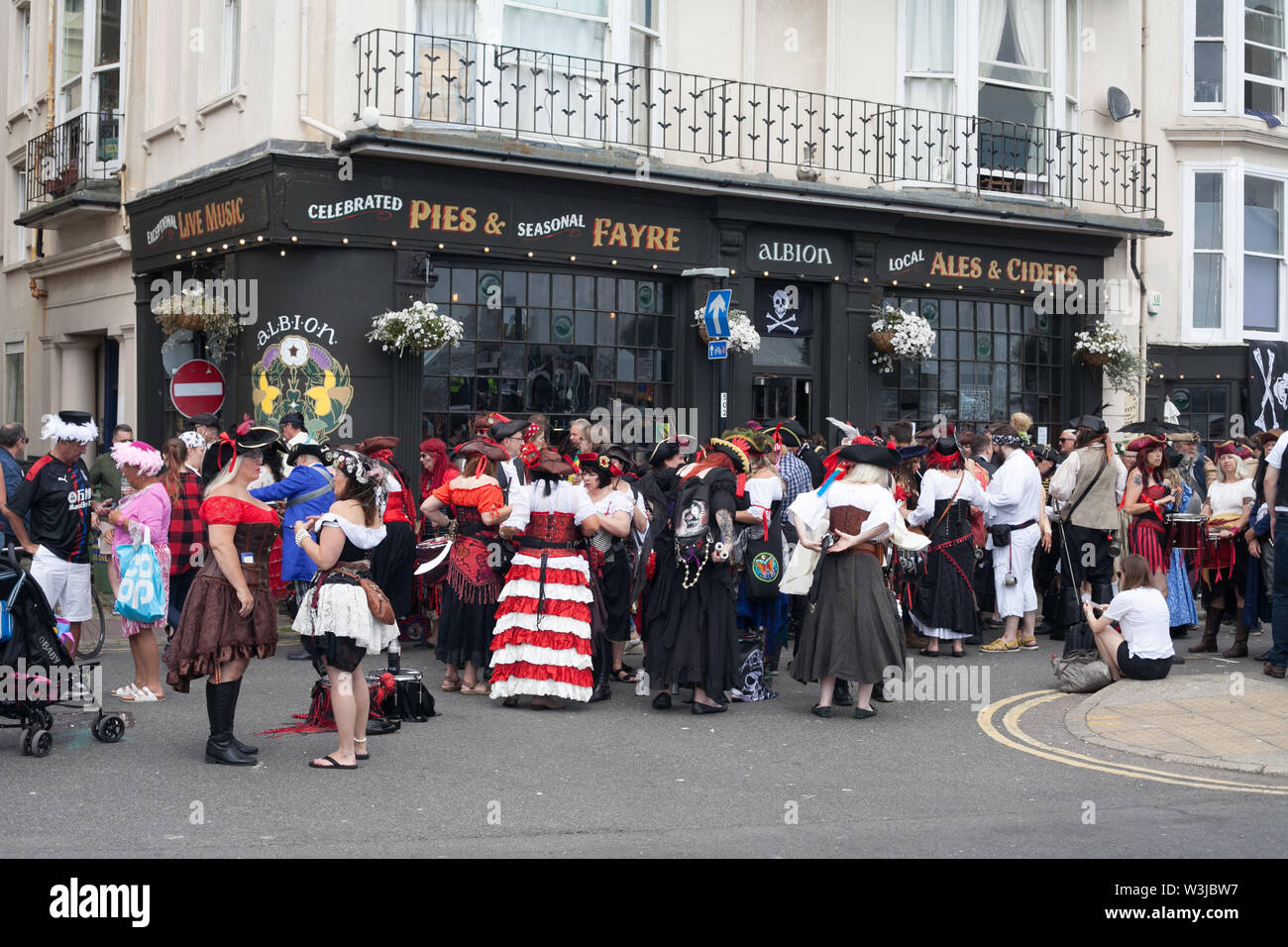 People dressed up as pirates chatting and having a drink outside a busy ...