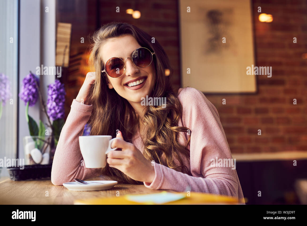 Happy woman drinking coffee at cafe Stock Photo - Alamy