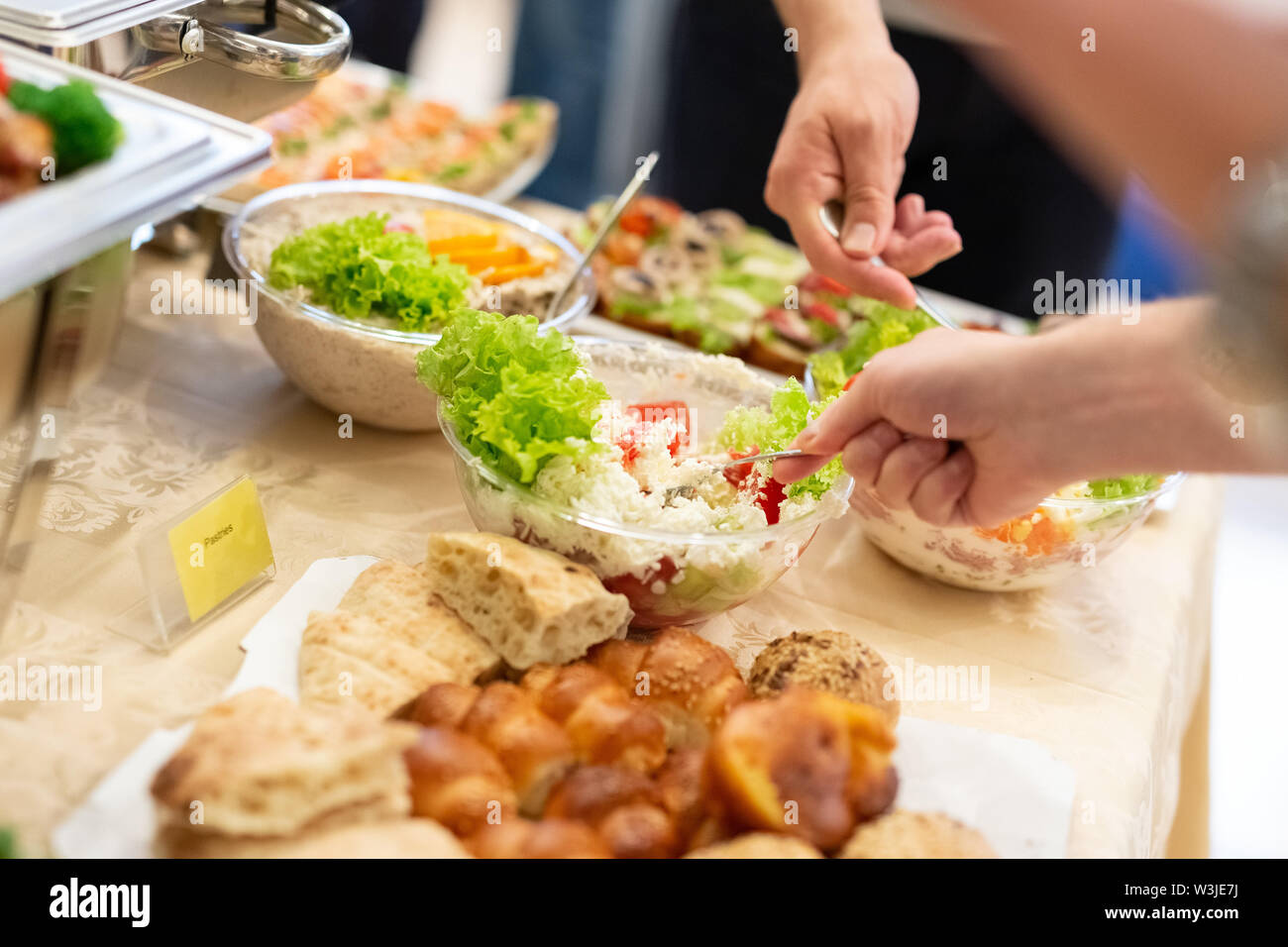 Hands picking up food from buffet catering table at event Stock Photo ...
