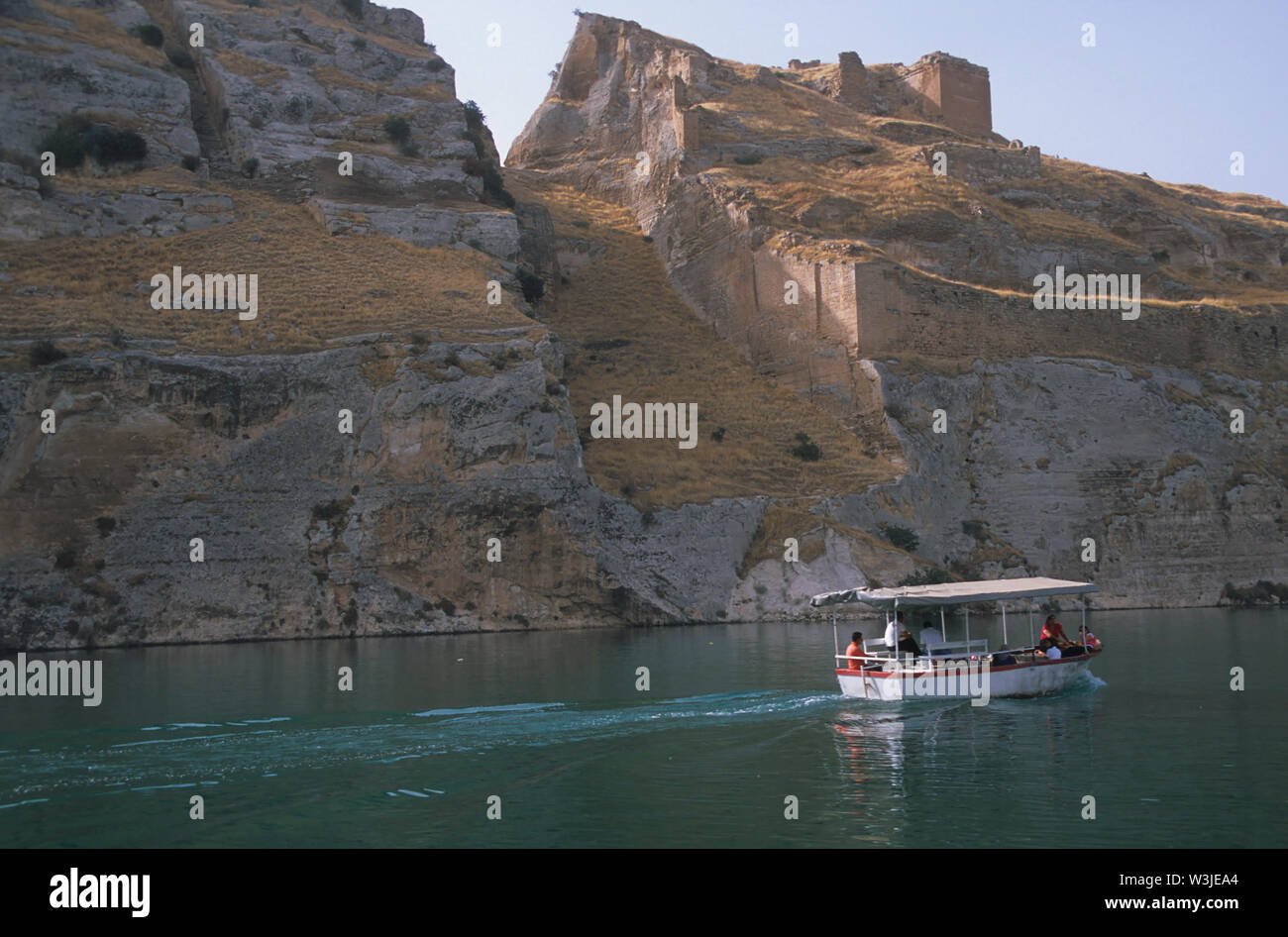 Small tour boat from Halfeti passing by the ancient rock fortress of ...