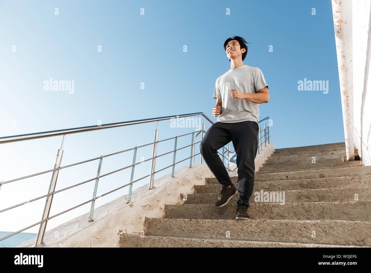 Healthy asian sportsman jogging outdoors, running down the stairs Stock ...