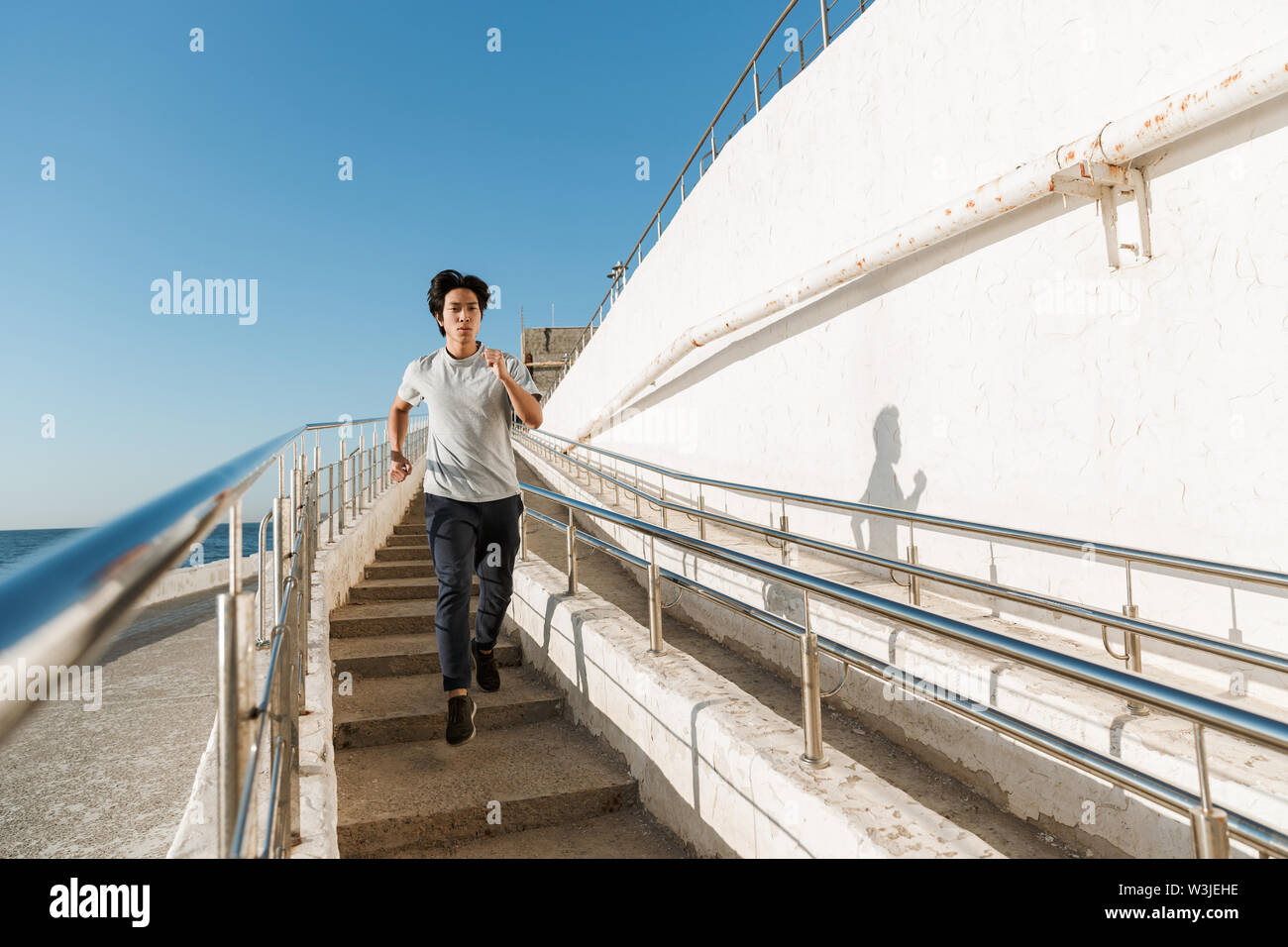 Healthy asian sportsman jogging outdoors, running down the stairs Stock ...