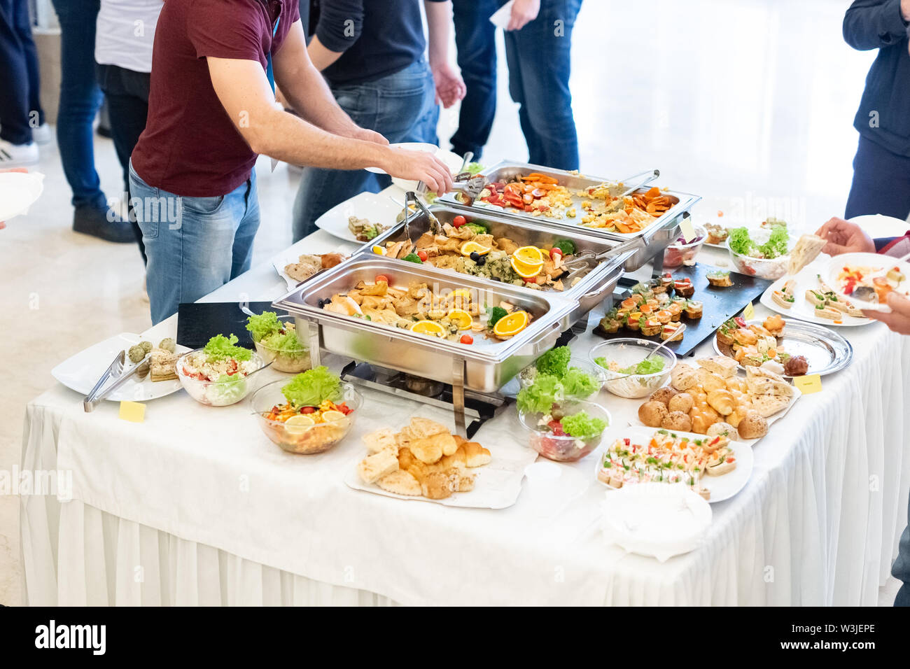Close up of people serving themselves in buffet of restaurant Stock ...