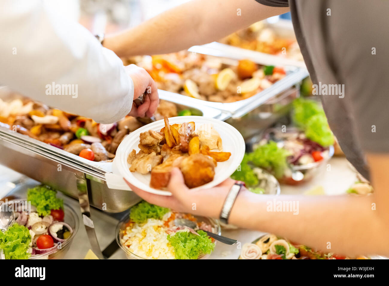 Close up of man hand holding plate with buffet catering food ...