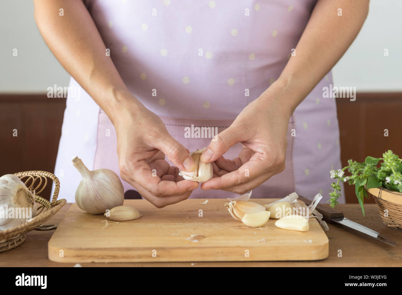 Woman peeling garlic preparation for cooking in the kitchen Stock Photo ...
