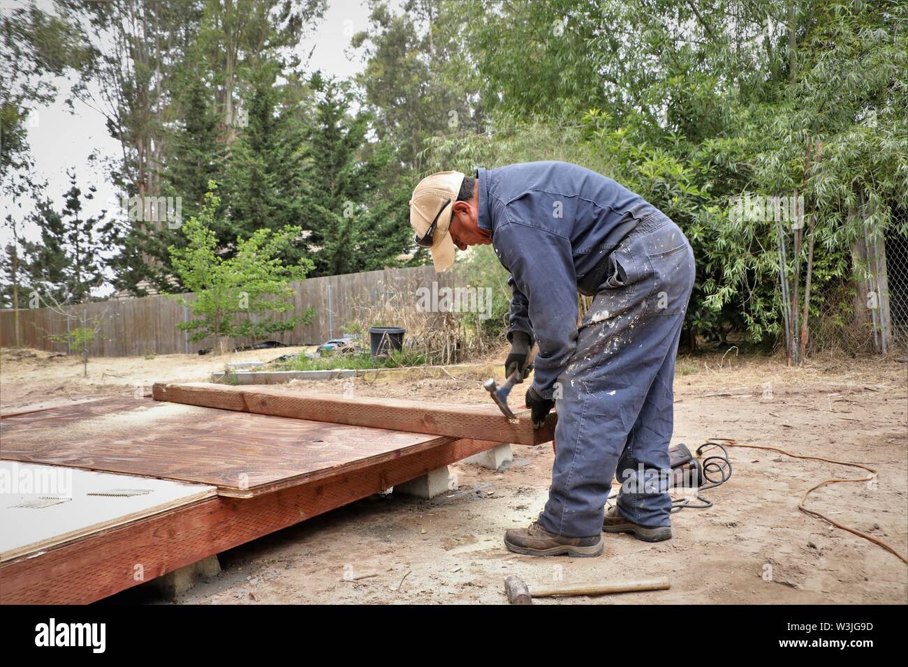Latin workers working on garden shed in California USA and resting for ...