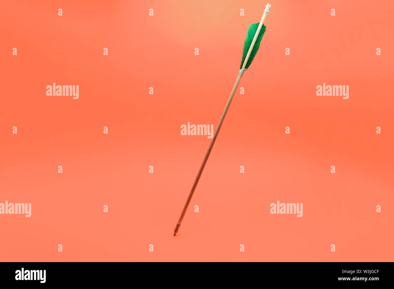 Old green wooden arrow on a beautiful peach background Stock Photo - Alamy