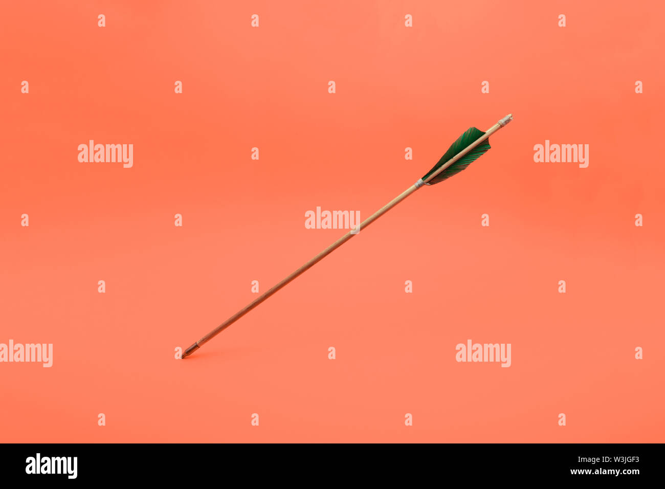 Old green wooden arrow on a beautiful peach background Stock Photo - Alamy
