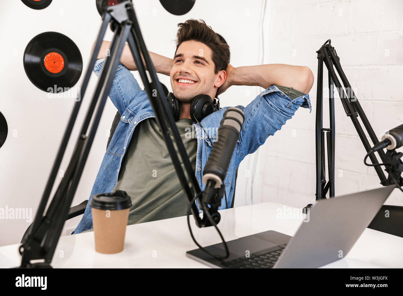 Handsome happy young male radio host broadcasting in studio, using ...