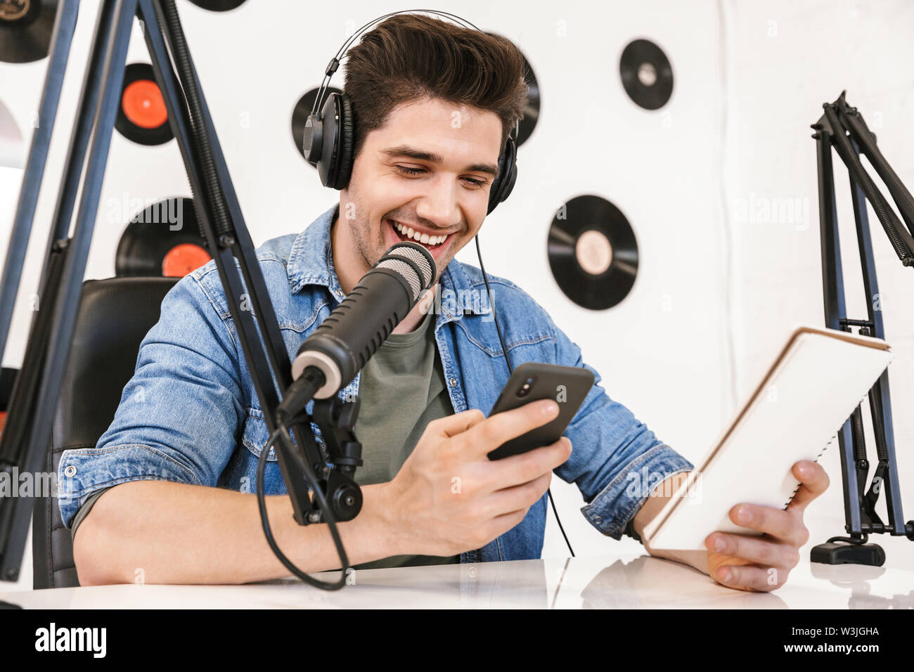 Handsome happy young male radio host broadcasting in studio, using ...