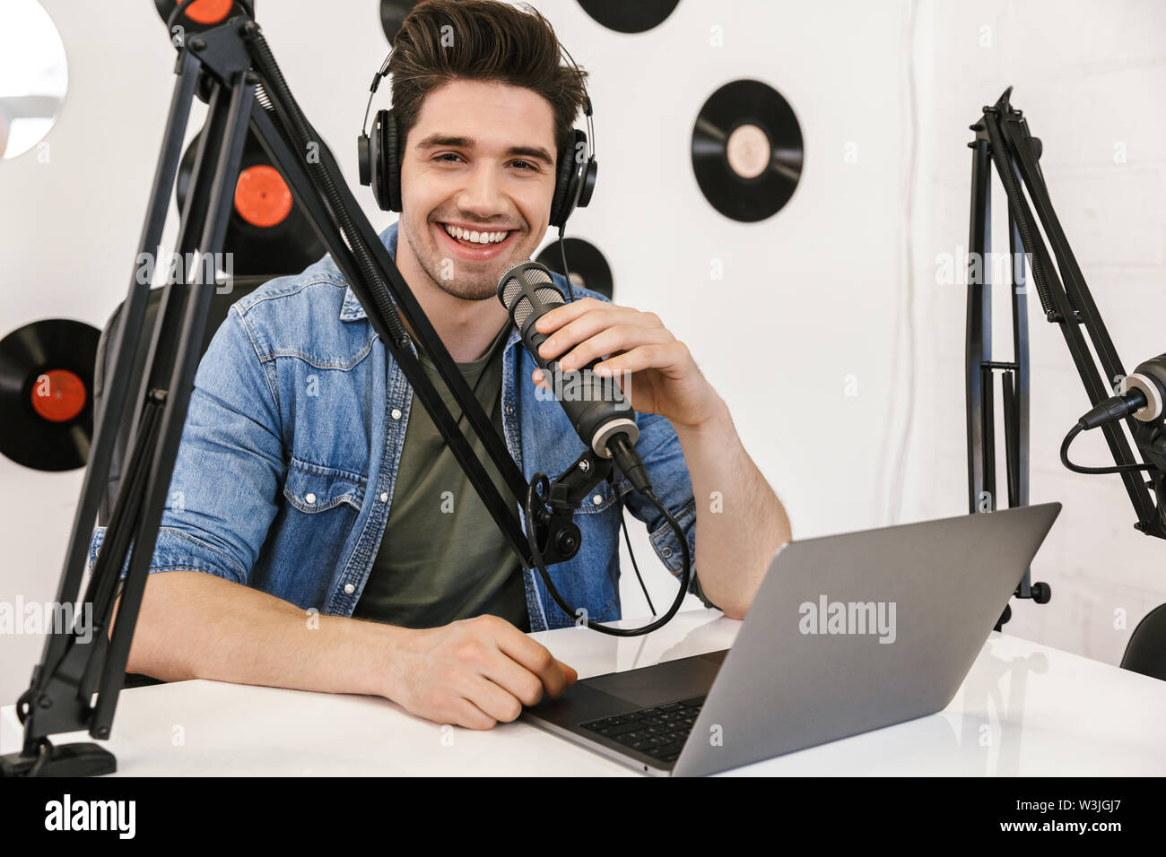 Handsome happy young male radio host broadcasting in studio, using ...