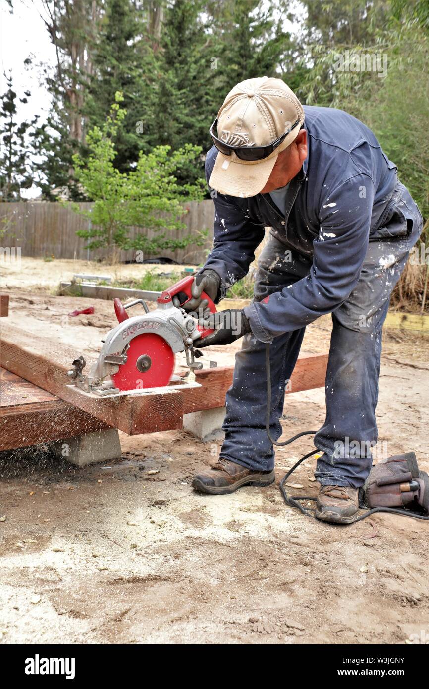 Latin workers working on garden shed in California USA and resting for ...