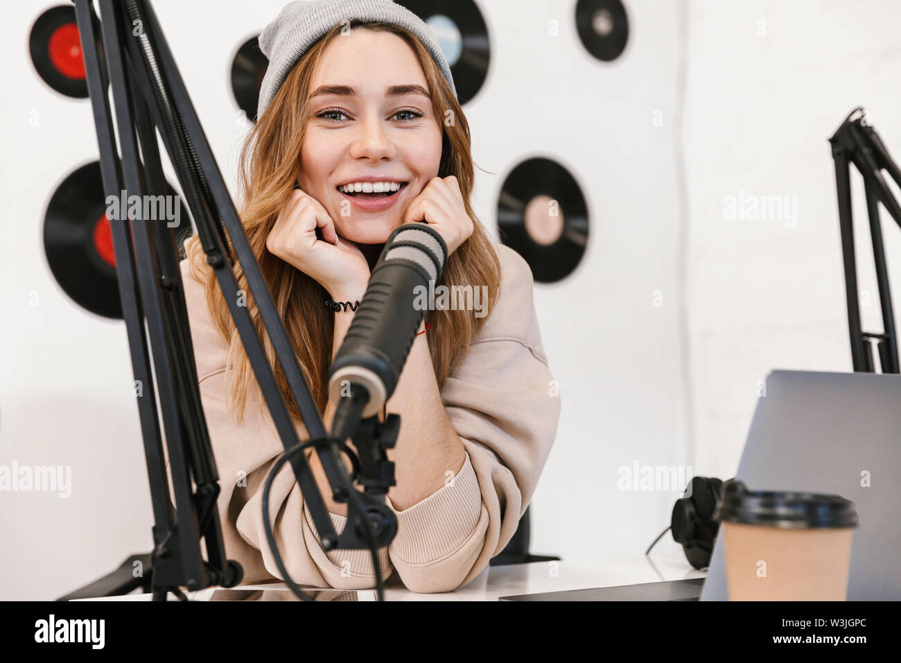 Beautiful happy young female radio host broadcasting in studio, using ...