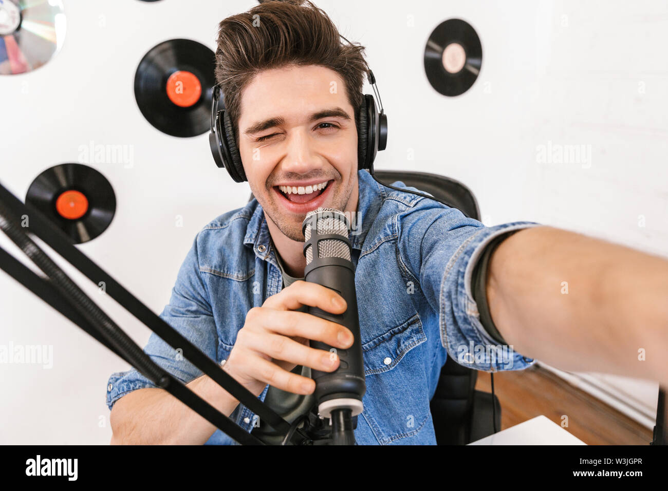 Image of a handsome young man radio host at the workspace with ...