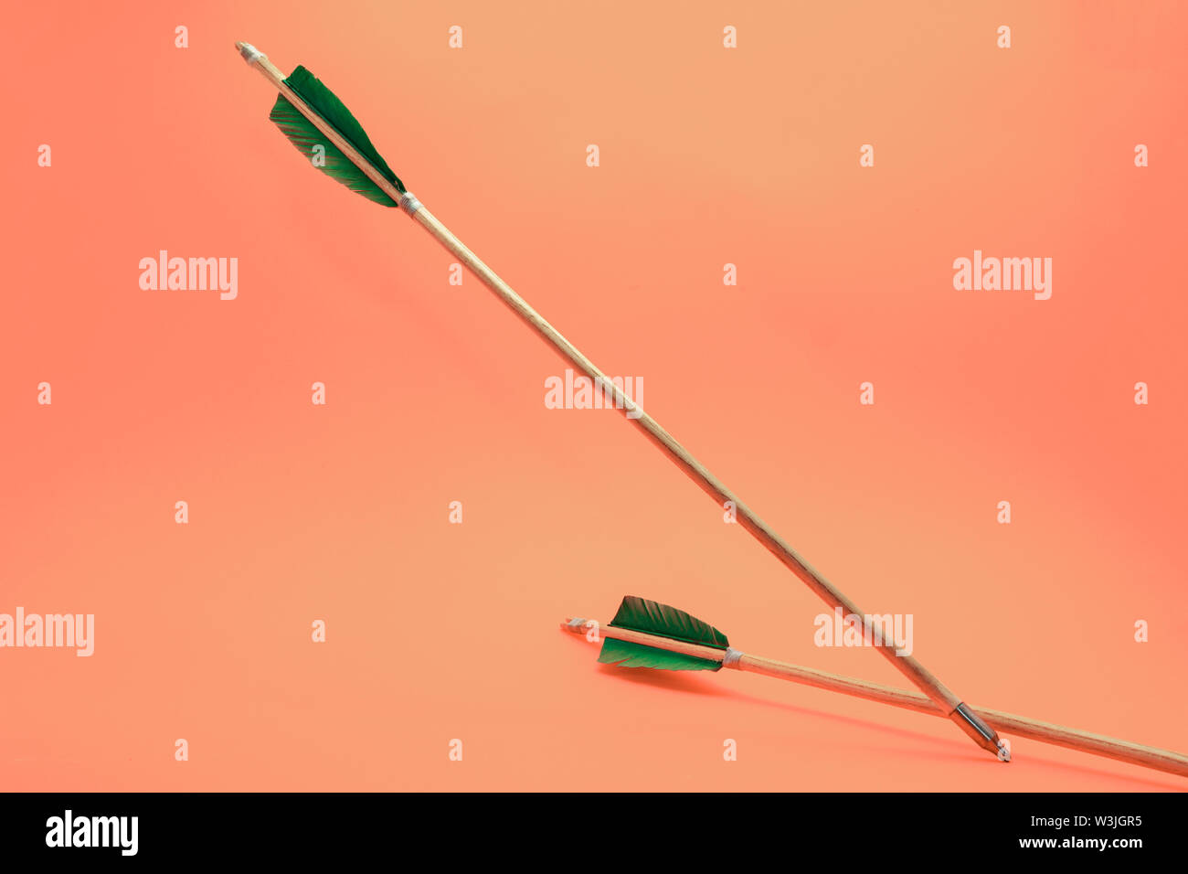 Old two green wooden arrow on a beautiful peach background Stock Photo ...