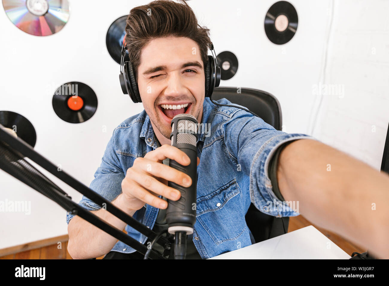 Image of a handsome young man radio host at the workspace with ...