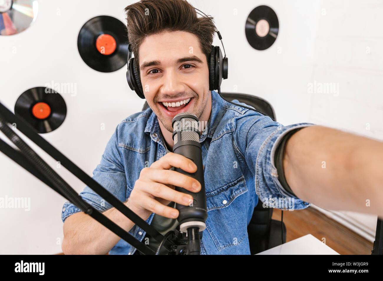 Image of a handsome young man radio host at the workspace with ...