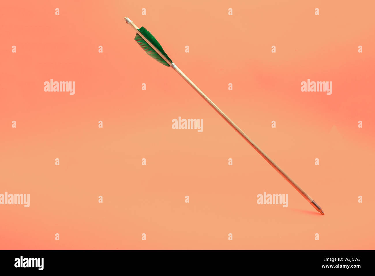 Old green wooden arrow on a beautiful peach background Stock Photo - Alamy