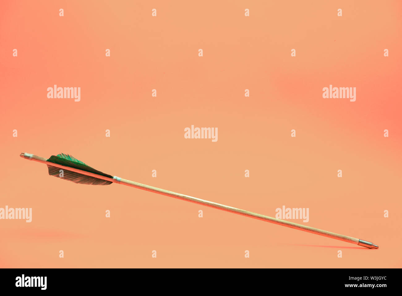 Old green wooden arrow on a beautiful peach background Stock Photo - Alamy