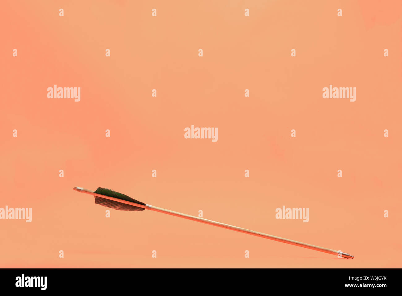 Old green wooden arrow on a beautiful peach background Stock Photo - Alamy