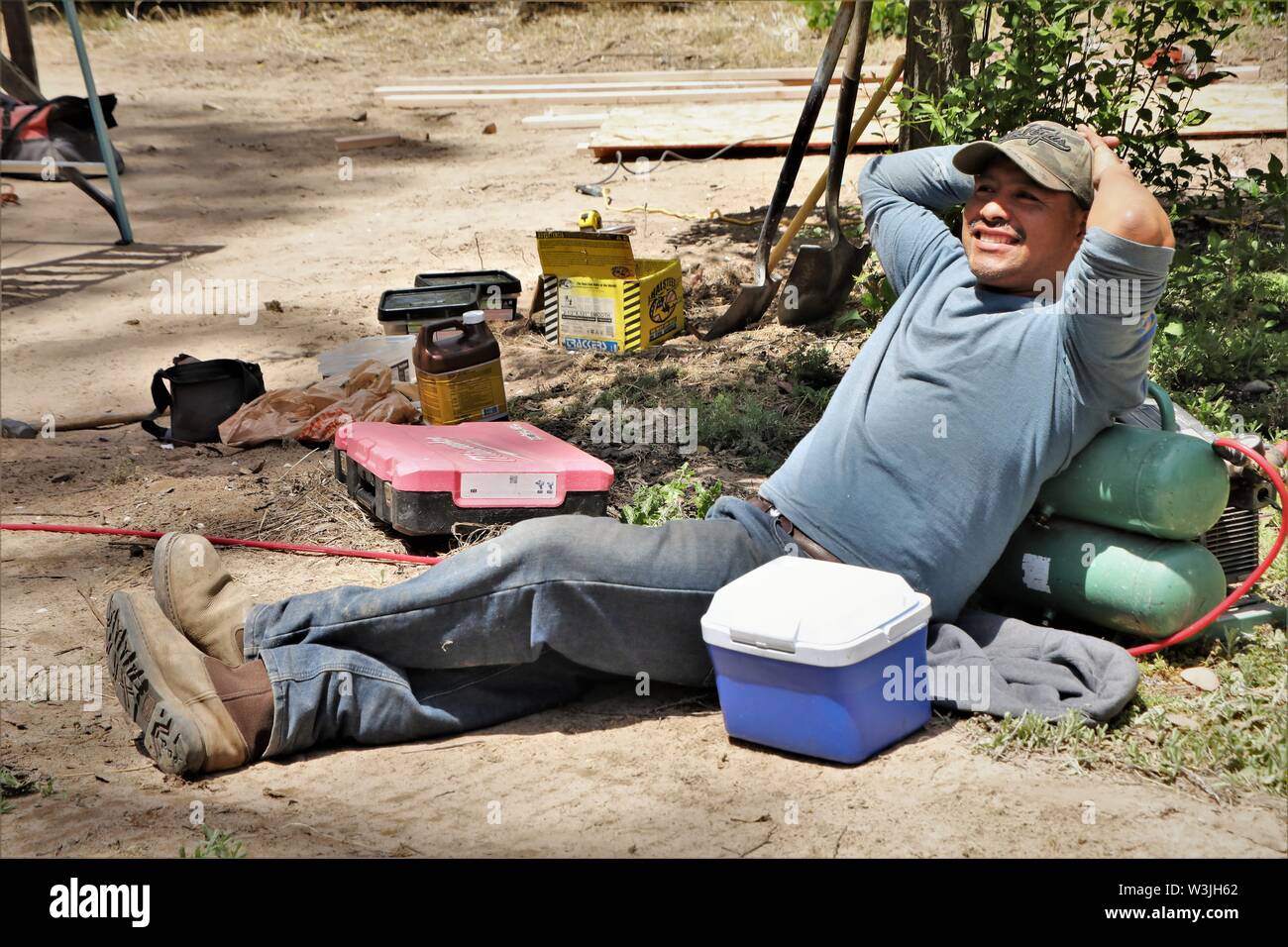 Latin workers working on garden shed in California USA and resting for ...