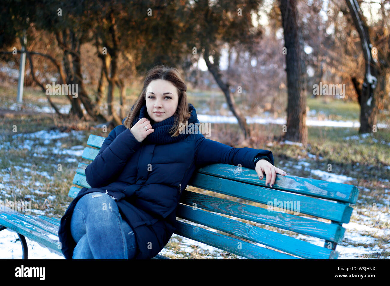 portrait of a cute girl sitting on the bench Stock Photo - Alamy