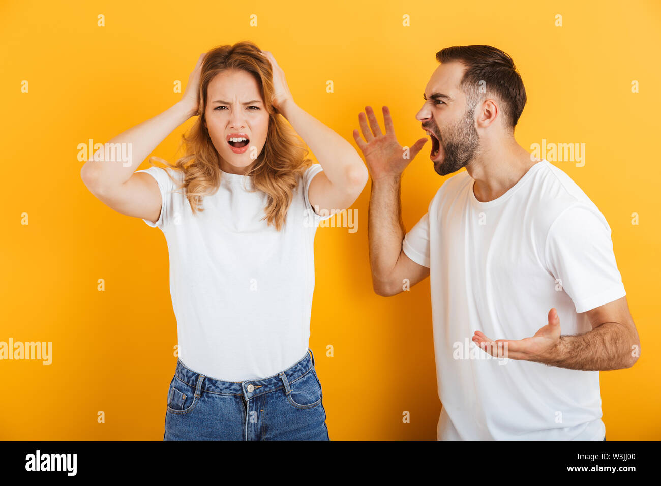 Image of arguing couple man and woman in basic t-shirts screaming at ...