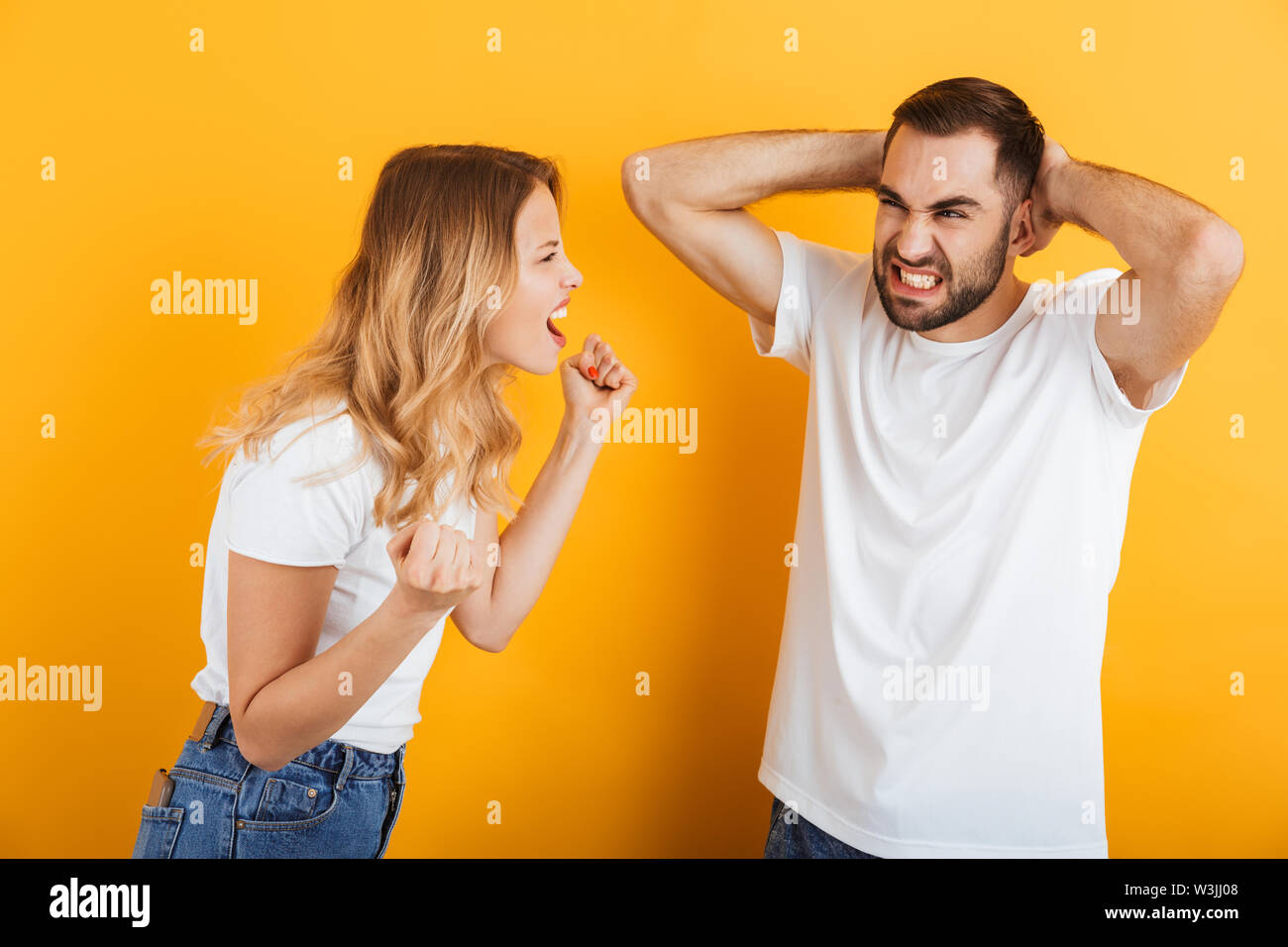 Image of annoyed couple man and woman in basic t-shirts screaming at ...