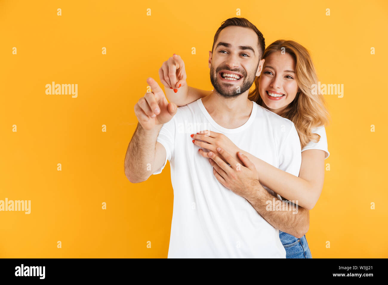 Image of pretty couple man and woman expressing wonder while pointing ...