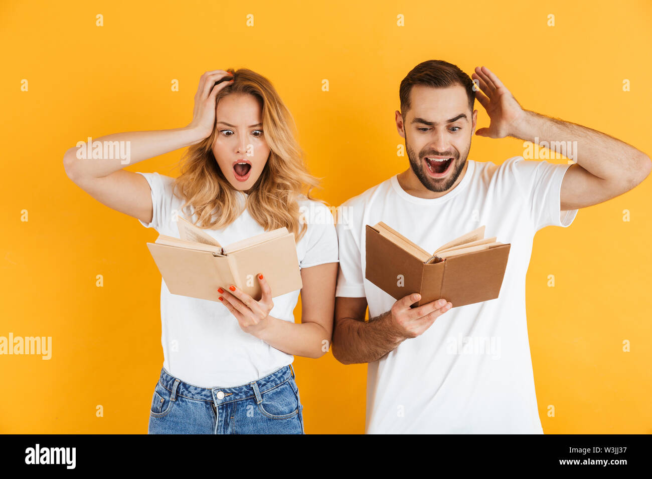 Image of shocked couple man and woman expressing wonder while reading ...