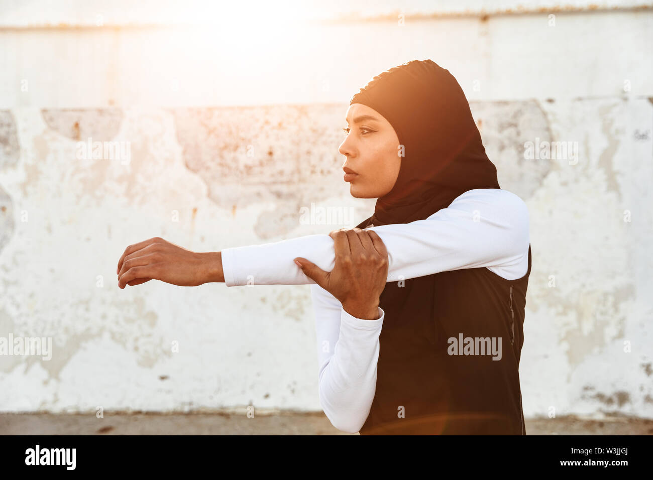 Image of a young concentrated muslim sports fitness woman dressed in ...