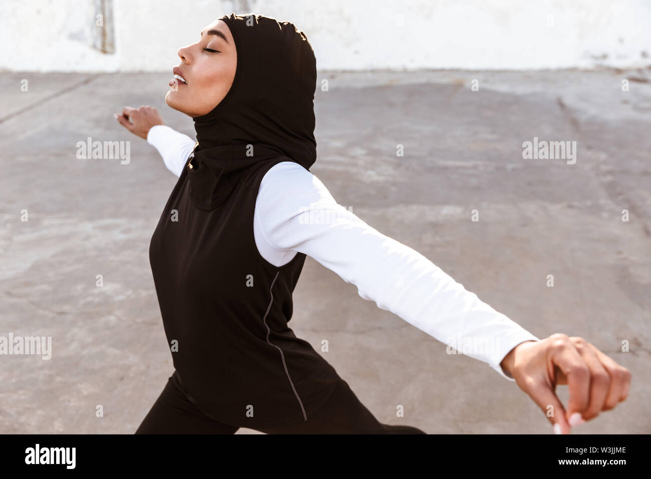 Image of a young concentrated muslim sports fitness woman dressed in ...