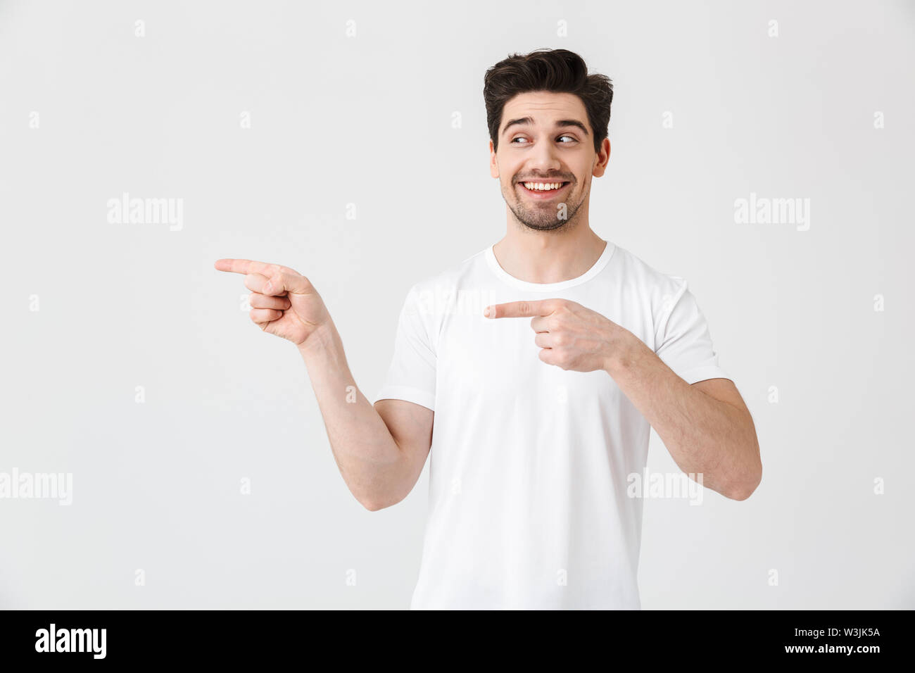 Image of a happy excited young man posing isolated over white wall ...