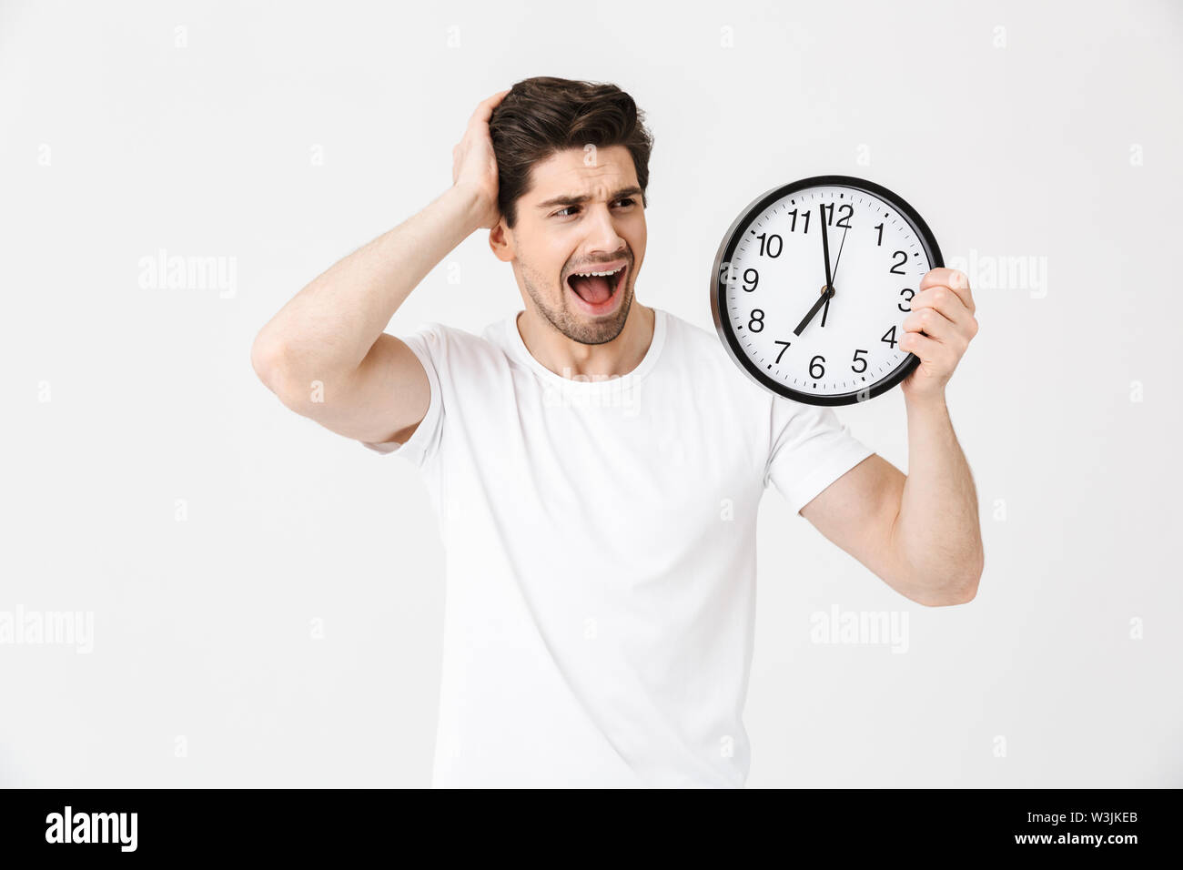 Image of screaming confused young man posing isolated over white wall ...