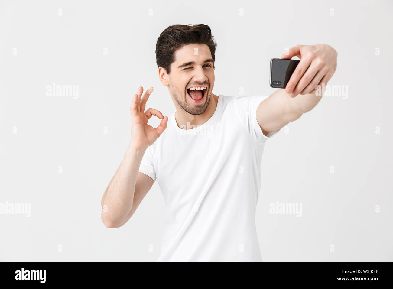 Image of happy emotional young man posing isolated over white wall ...