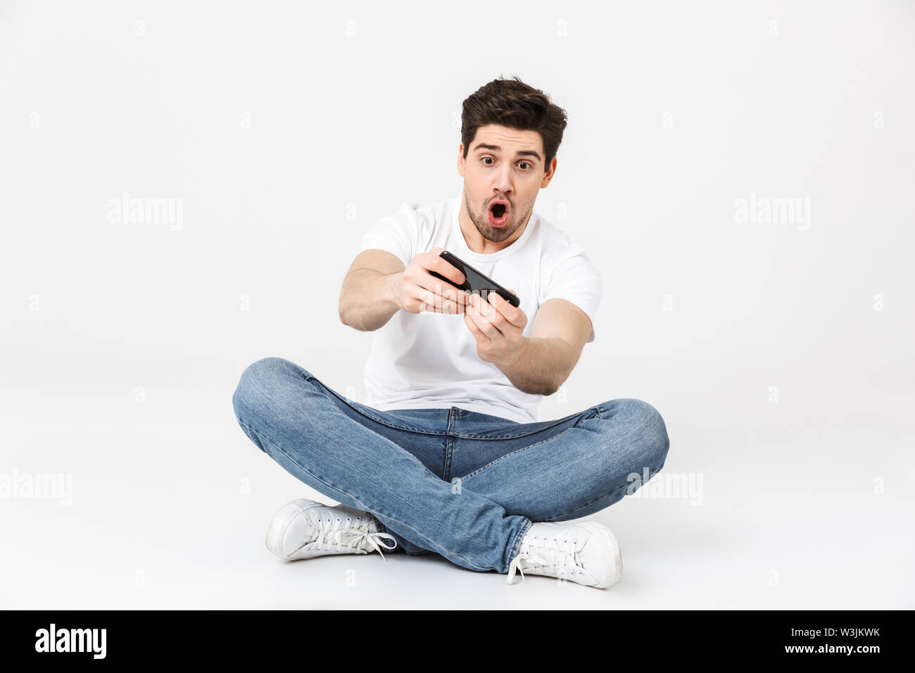 Image of a nervous young man posing isolated over white wall background ...
